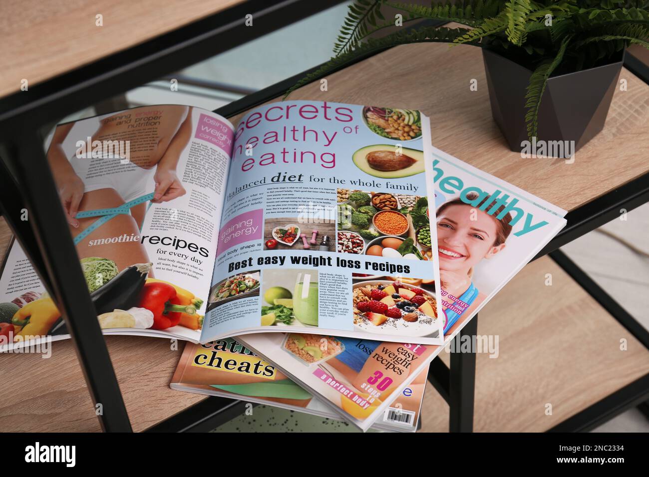 Different lifestyle magazines on shelving unit indoors Stock Photo - Alamy