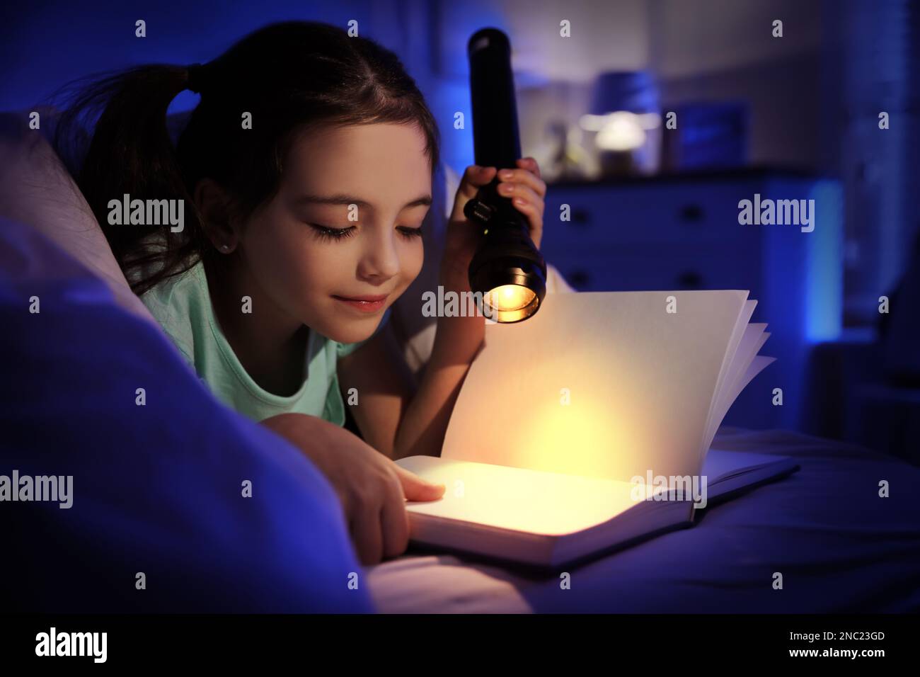 Little girl with flashlight reading fairy tale in dark bedroom Stock ...