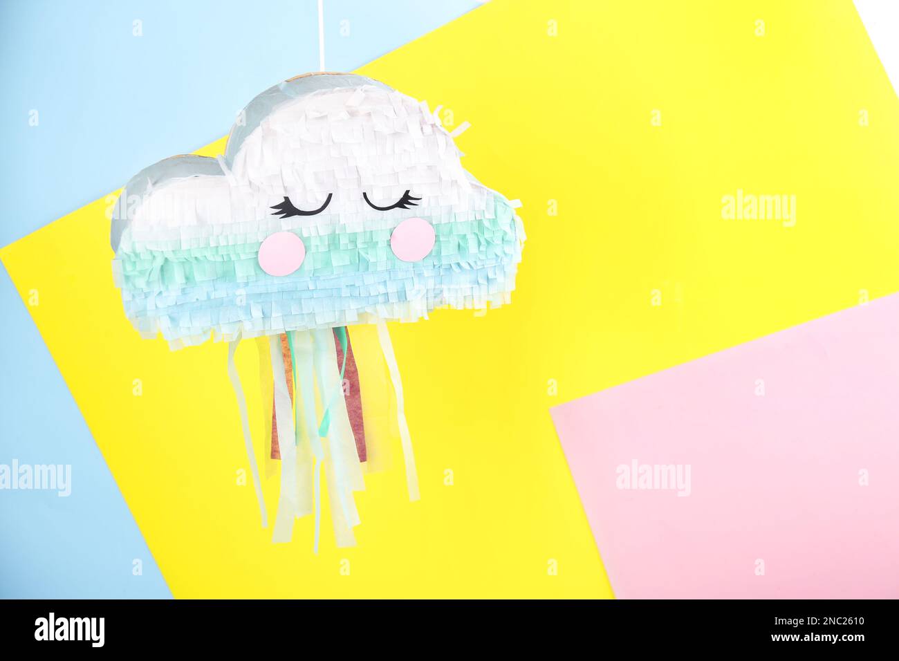Cloud shaped pinata hanging on color background. Space for text Stock ...