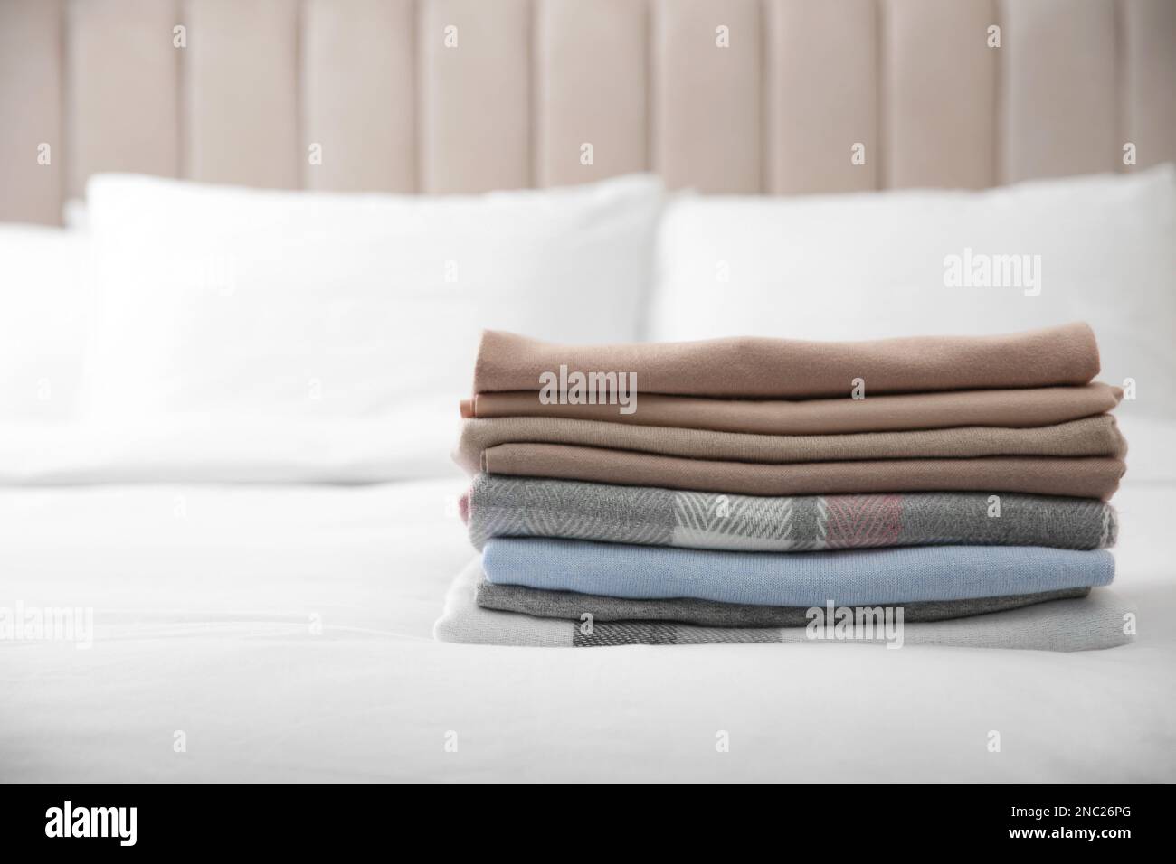 Stack of folded cashmere clothes on bed Stock Photo - Alamy
