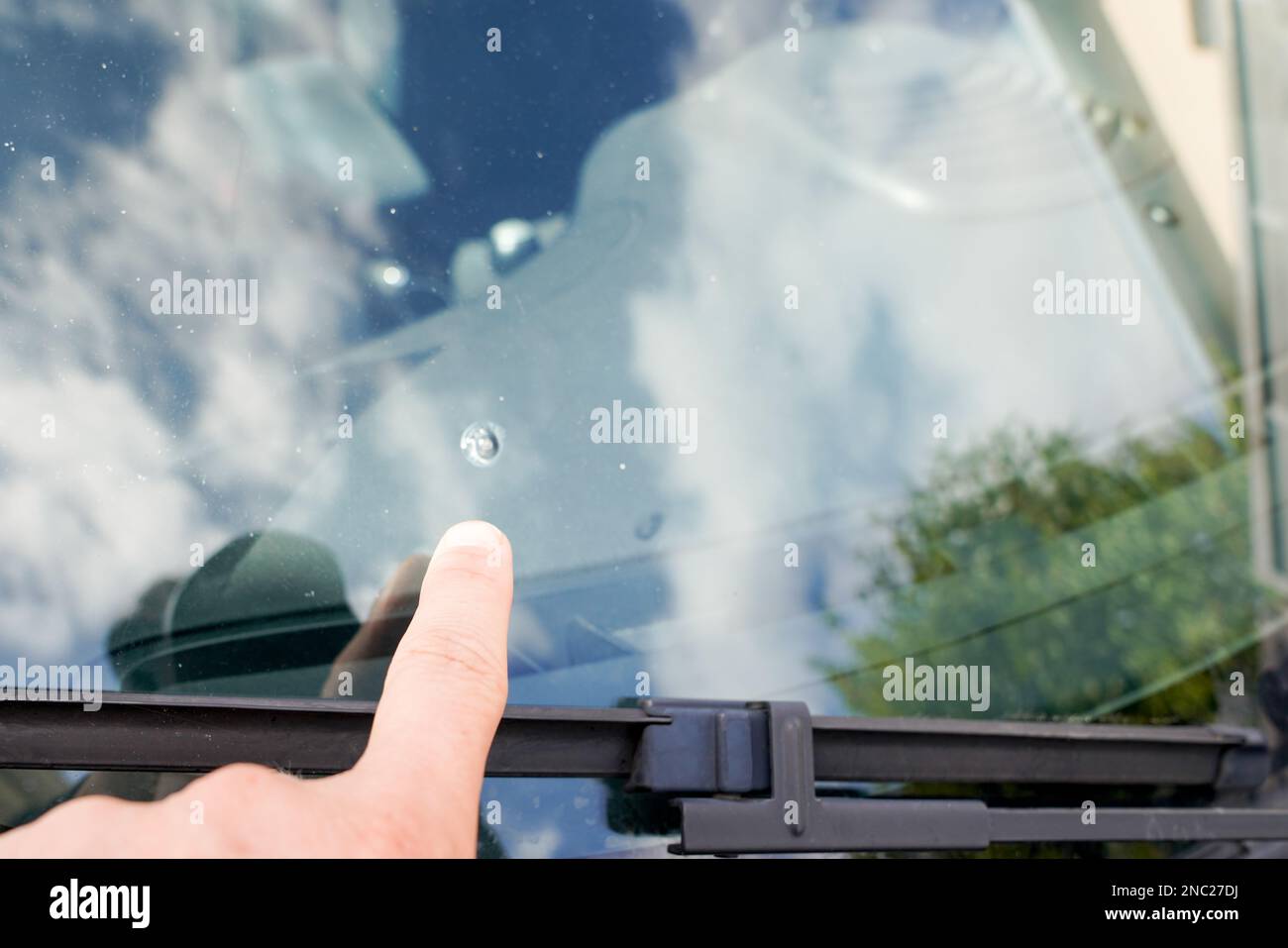 finger hand man pointing broken windshield of a car traces of oncoming ...