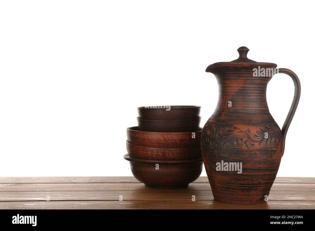 Different clay dishware on wooden table against white background Stock ...