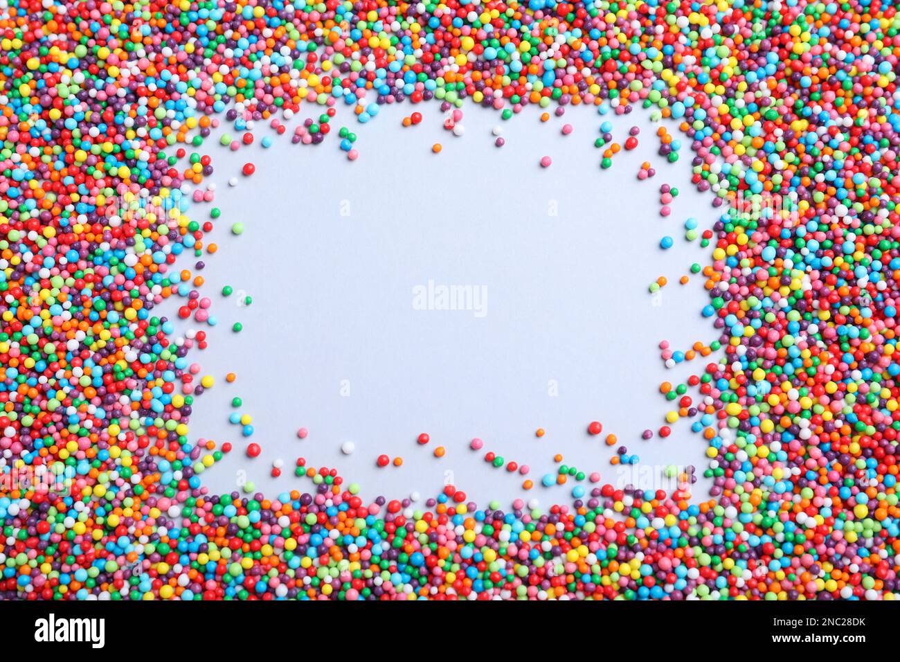 Frame of colorful sprinkles on light grey background, flat lay with ...