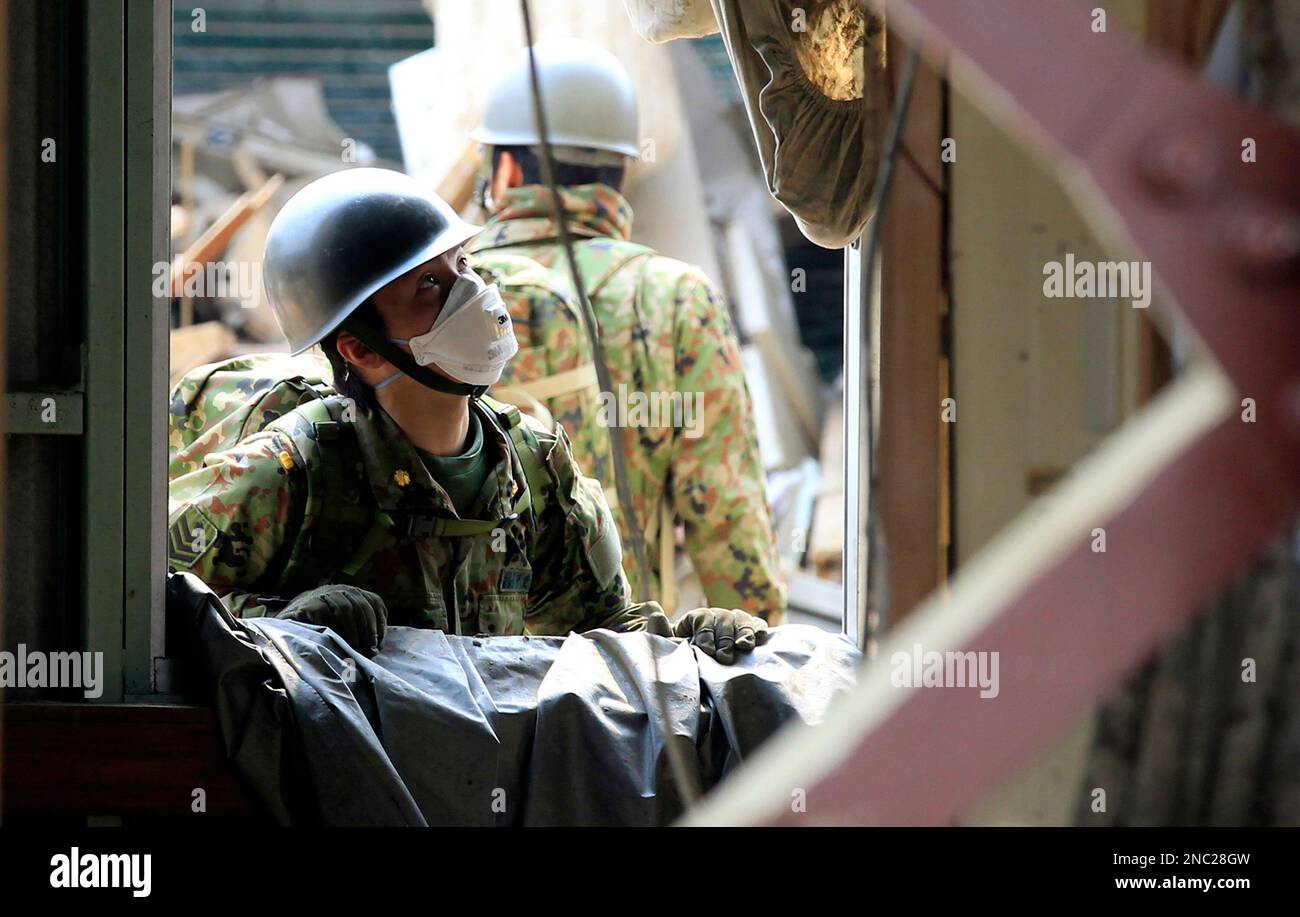 A member of the Japan Ground Self-Defense Force looks for the victims ...