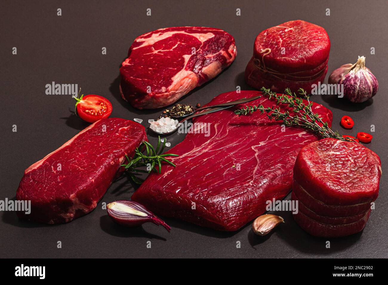 Set of various steaks with classic spices and herbs. Fresh raw meat ...