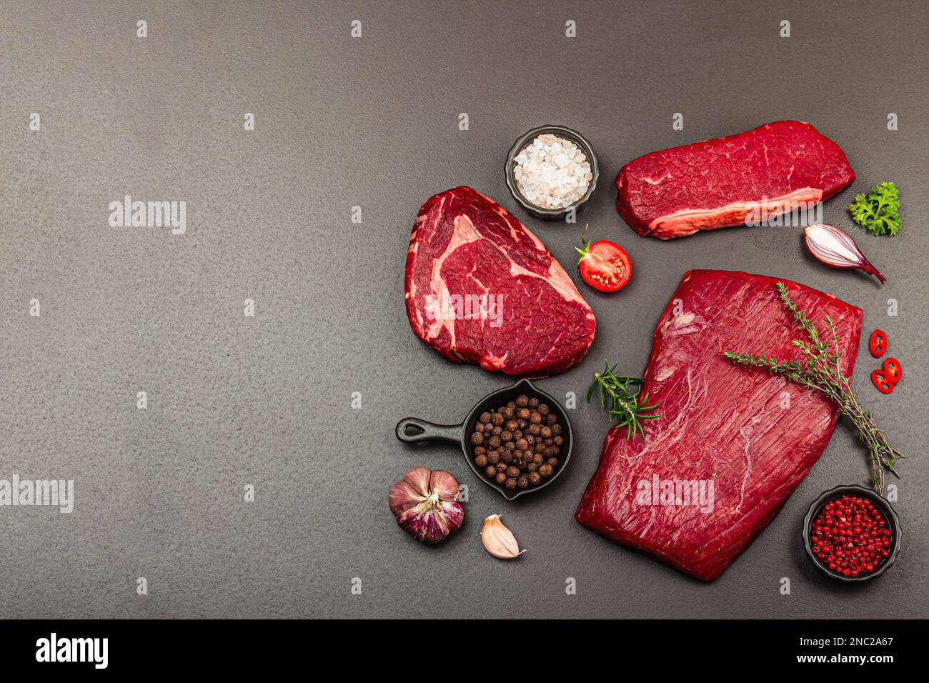 Set of various steaks with classic spices and herbs. Fresh raw meat ...