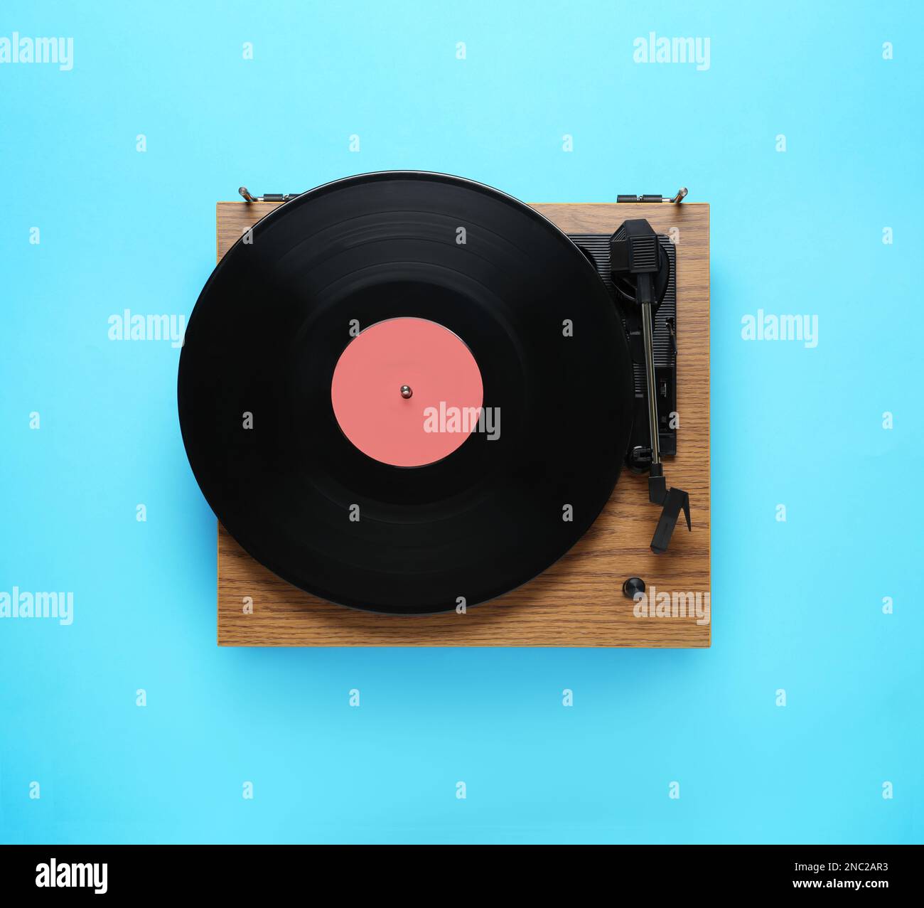 Modern turntable with vinyl record on light blue background, top view ...