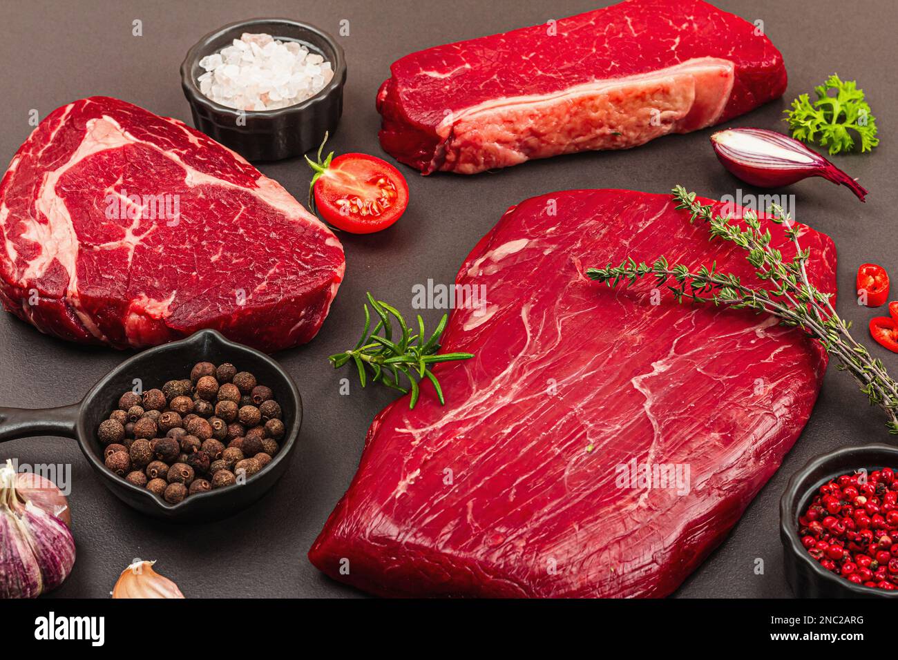 Set of various steaks with classic spices and herbs. Fresh raw meat ...
