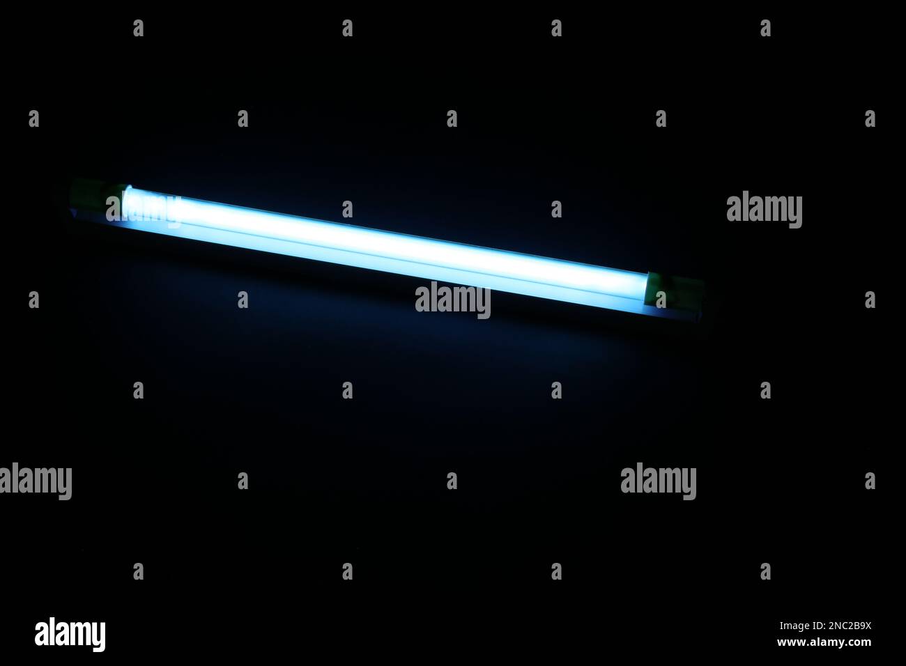 Modern ultraviolet lamp glowing on black background Stock Photo - Alamy