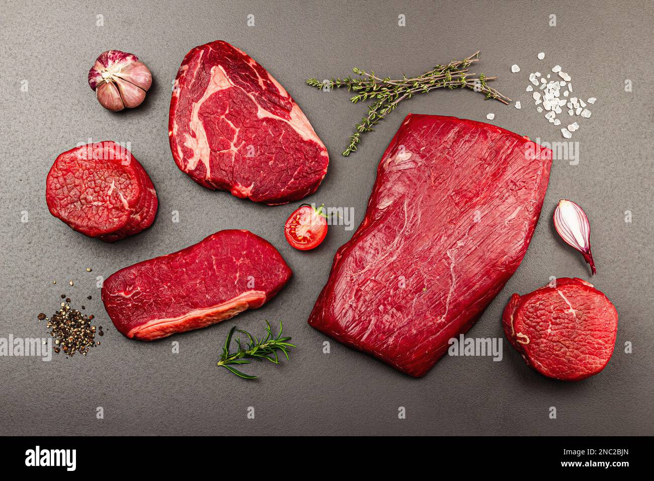 Set of various steaks with classic spices and herbs. Fresh raw meat ...