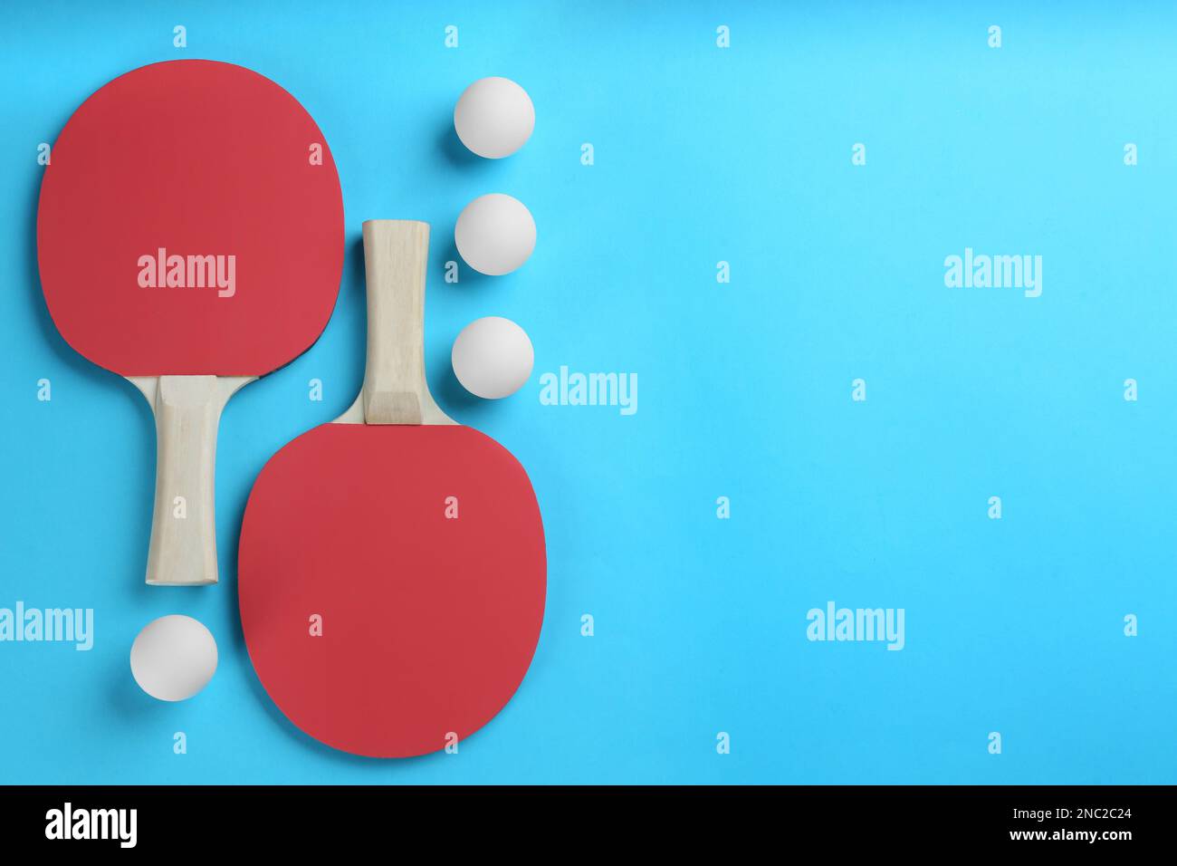 Ping pong rackets and balls on light blue background, flat lay. Space ...