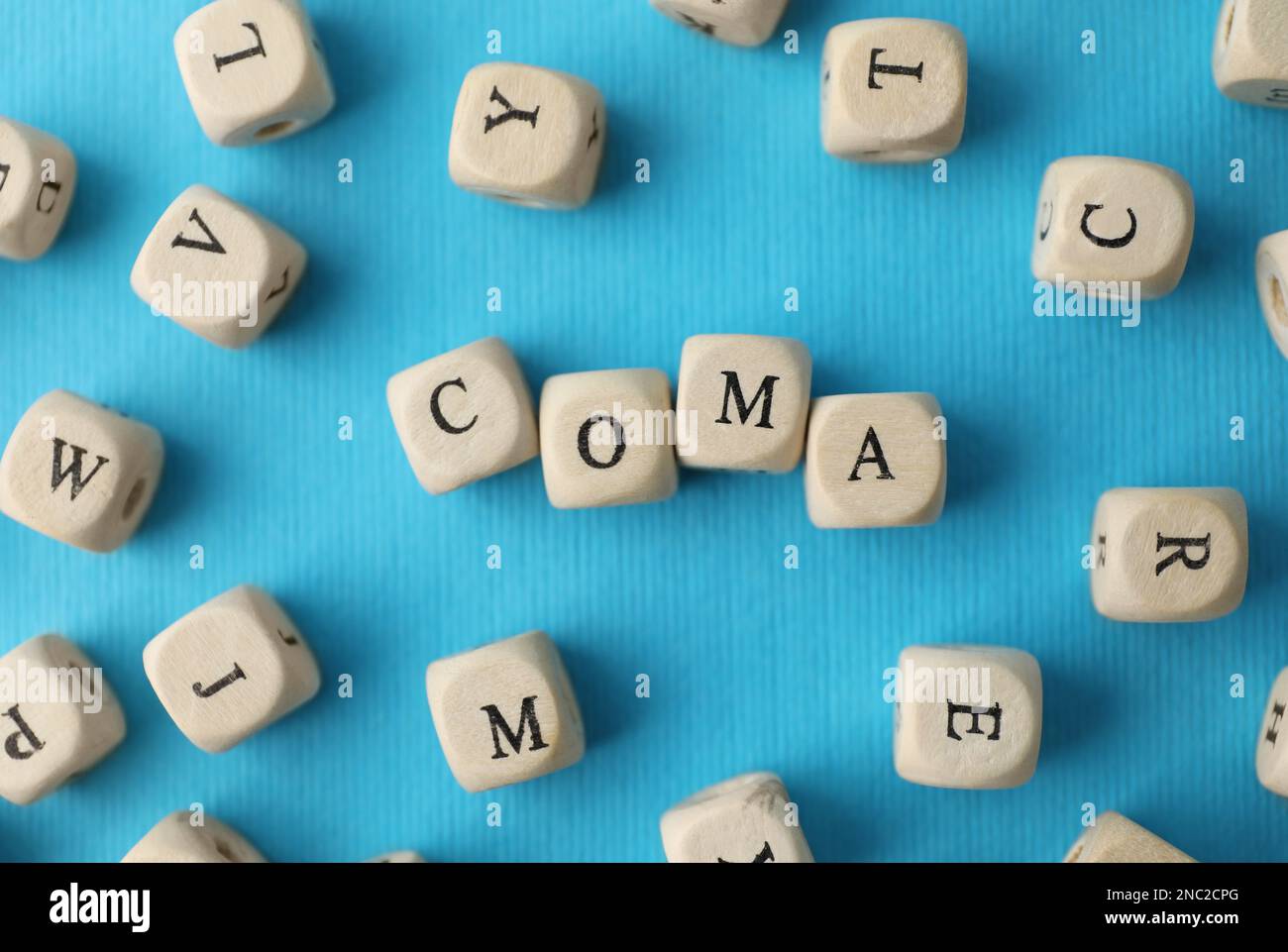 Wooden cubes with word Coma among others on light blue background, flat ...