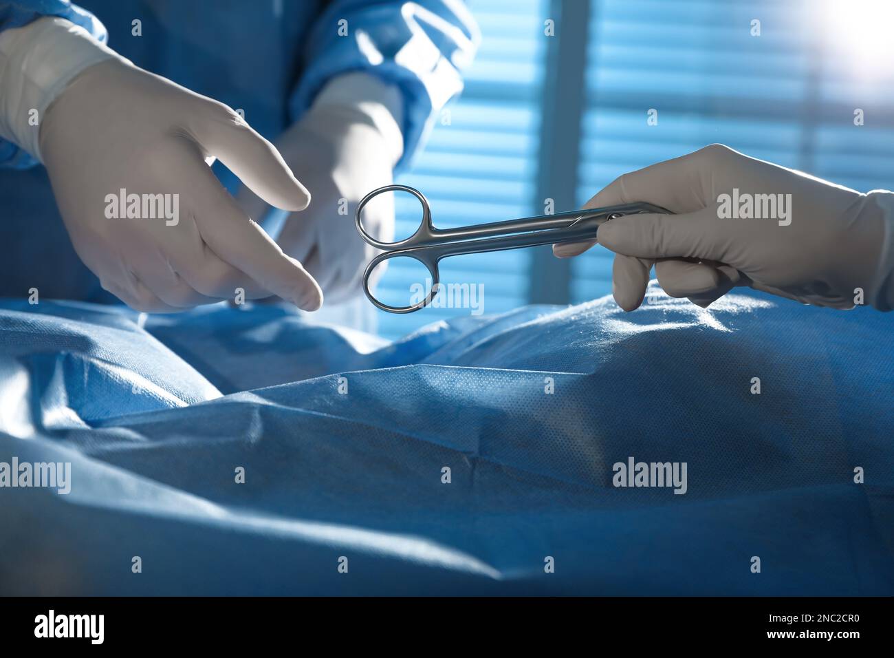 Professional surgeons with instruments performing operation in clinic ...