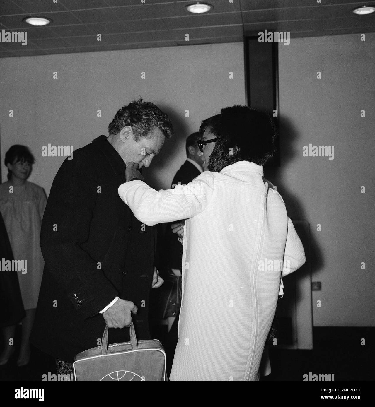 Singer Shirley Bassey adjusts the collar of actor Peter Finch at London ...
