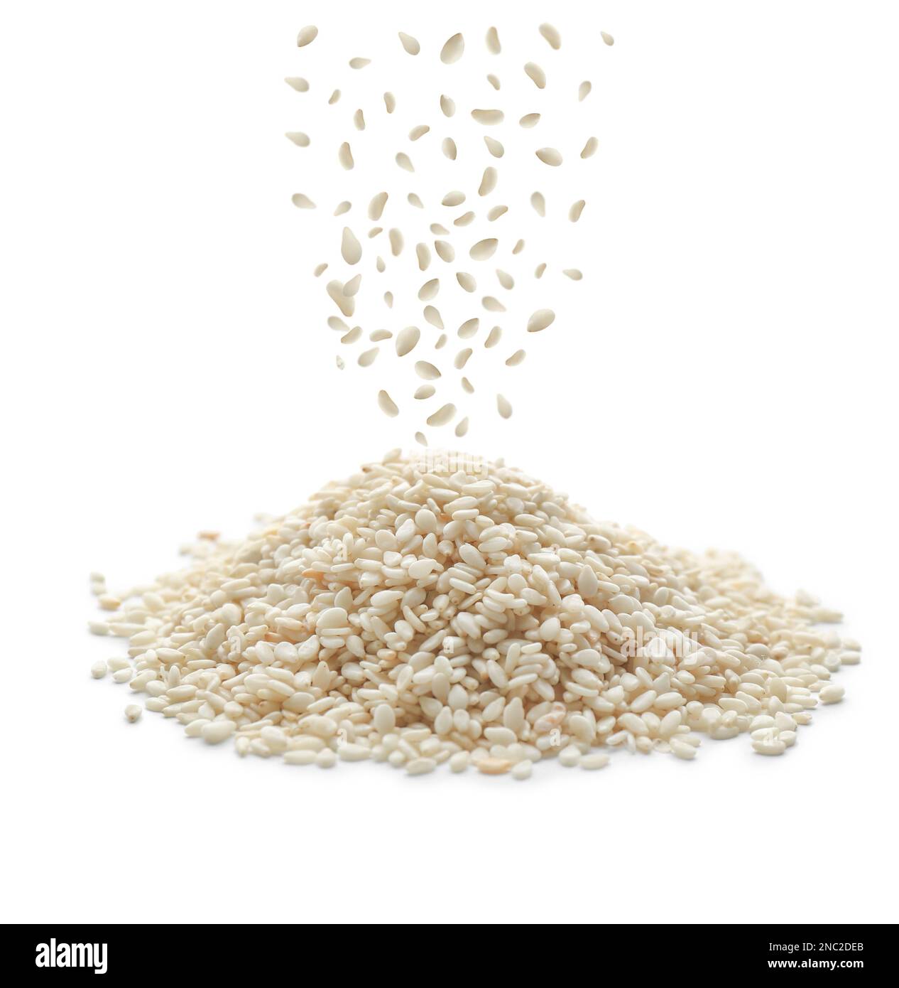Sesame seeds falling into pile on white background Stock Photo - Alamy