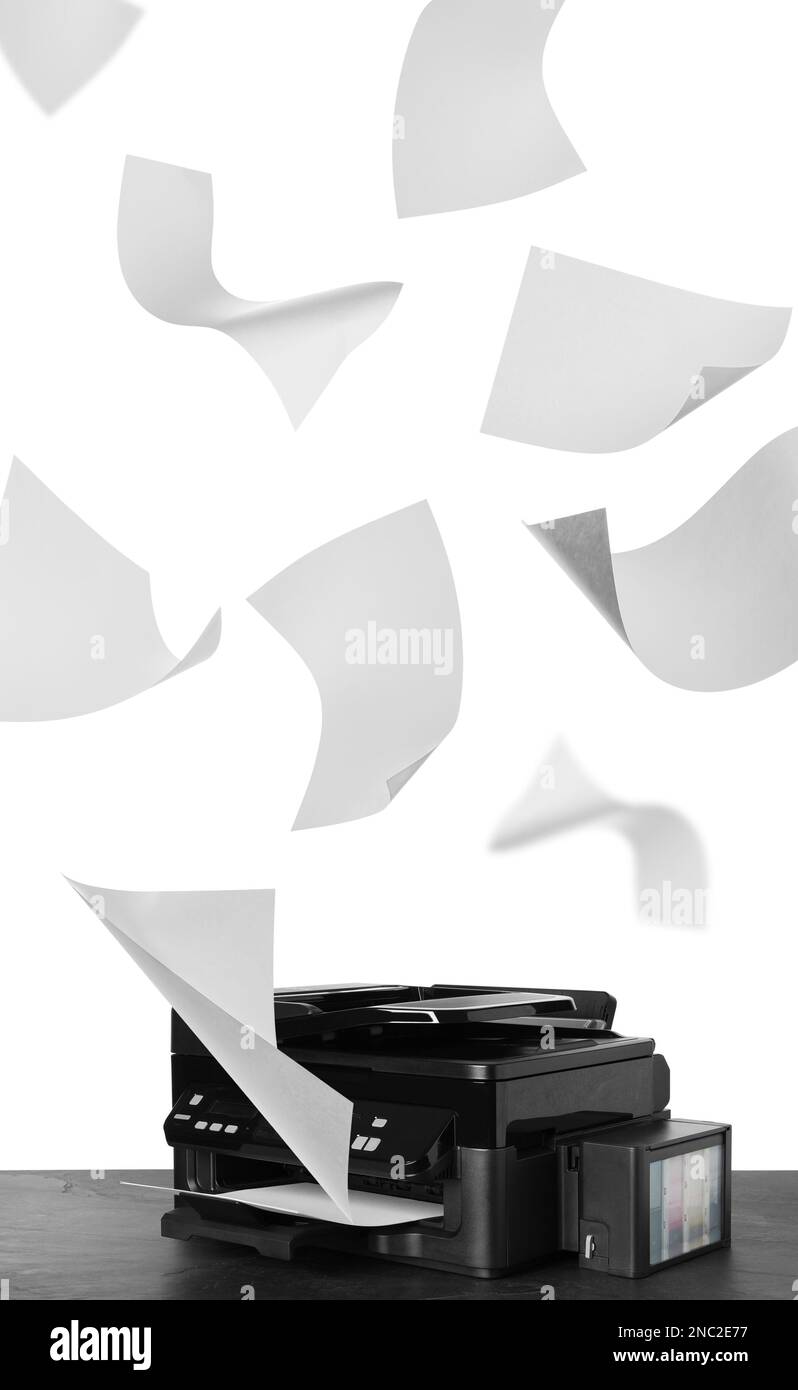 Modern multifunction printer on table and flying sheets of paper ...