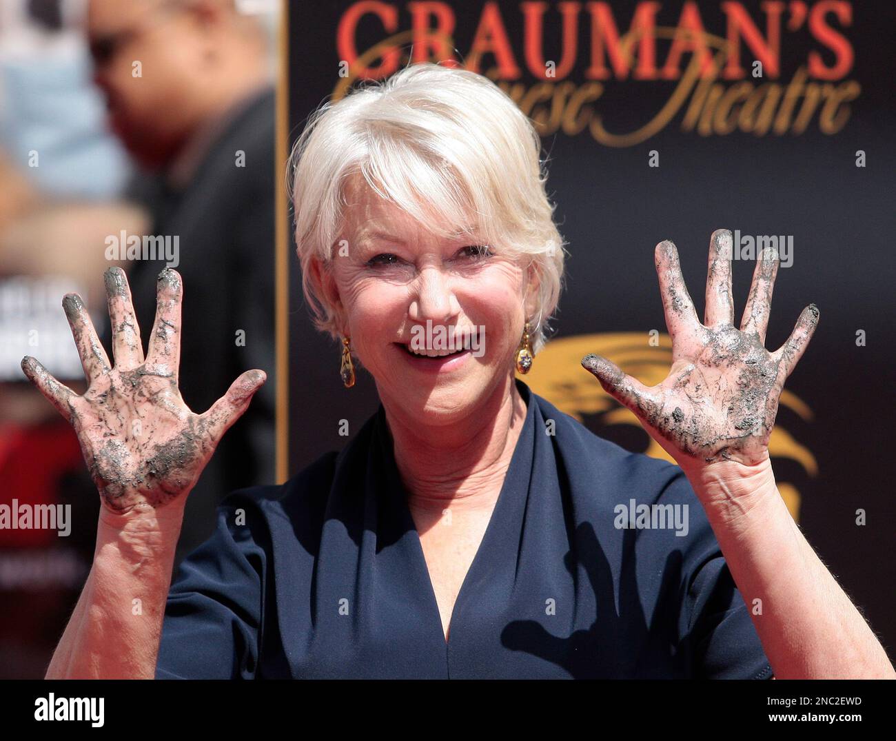 Actress Helen Mirren shows her cement-covered hands after placing her ...