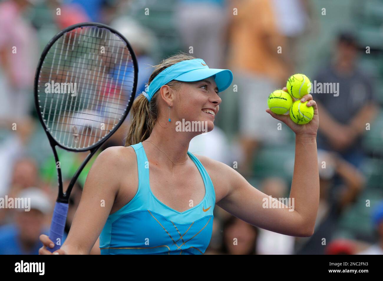 Maria Sharapova of Russia prepares to hit tennis balls into the stands ...