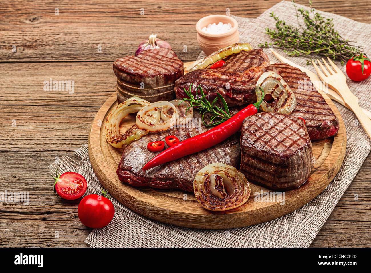 Grilled set of various steaks with vegetables, spices and herbs ...