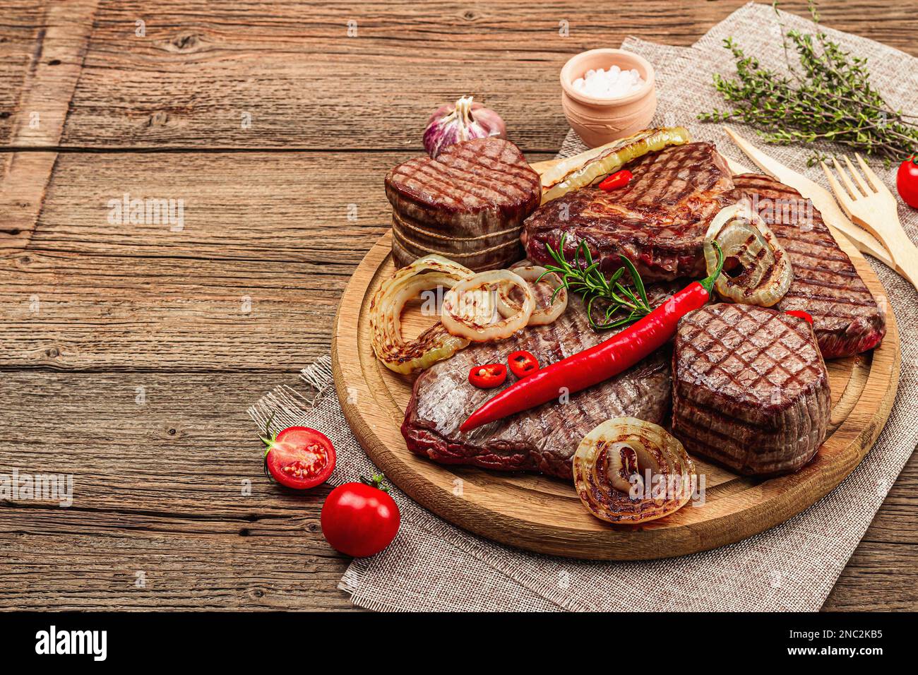 Grilled set of various steaks with vegetables, spices and herbs ...
