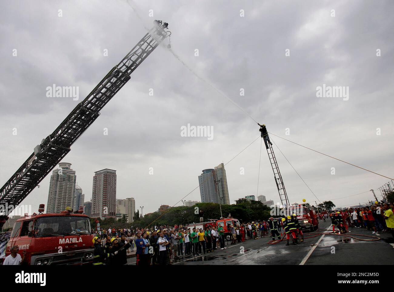 A Filipino fireman balances on top of a ladder as he trains his hose on ...