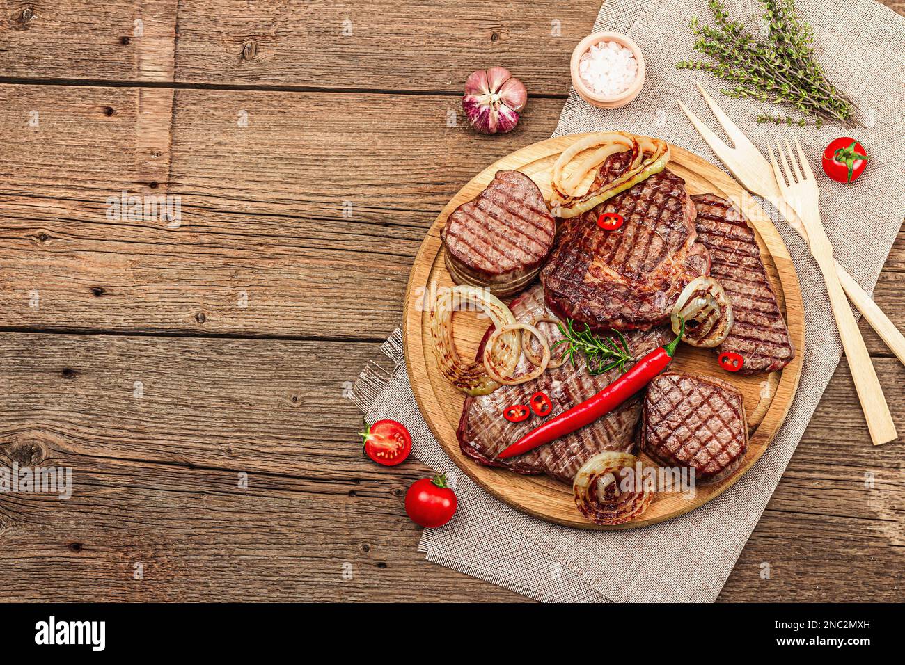 Grilled set of various steaks with vegetables, spices and herbs ...