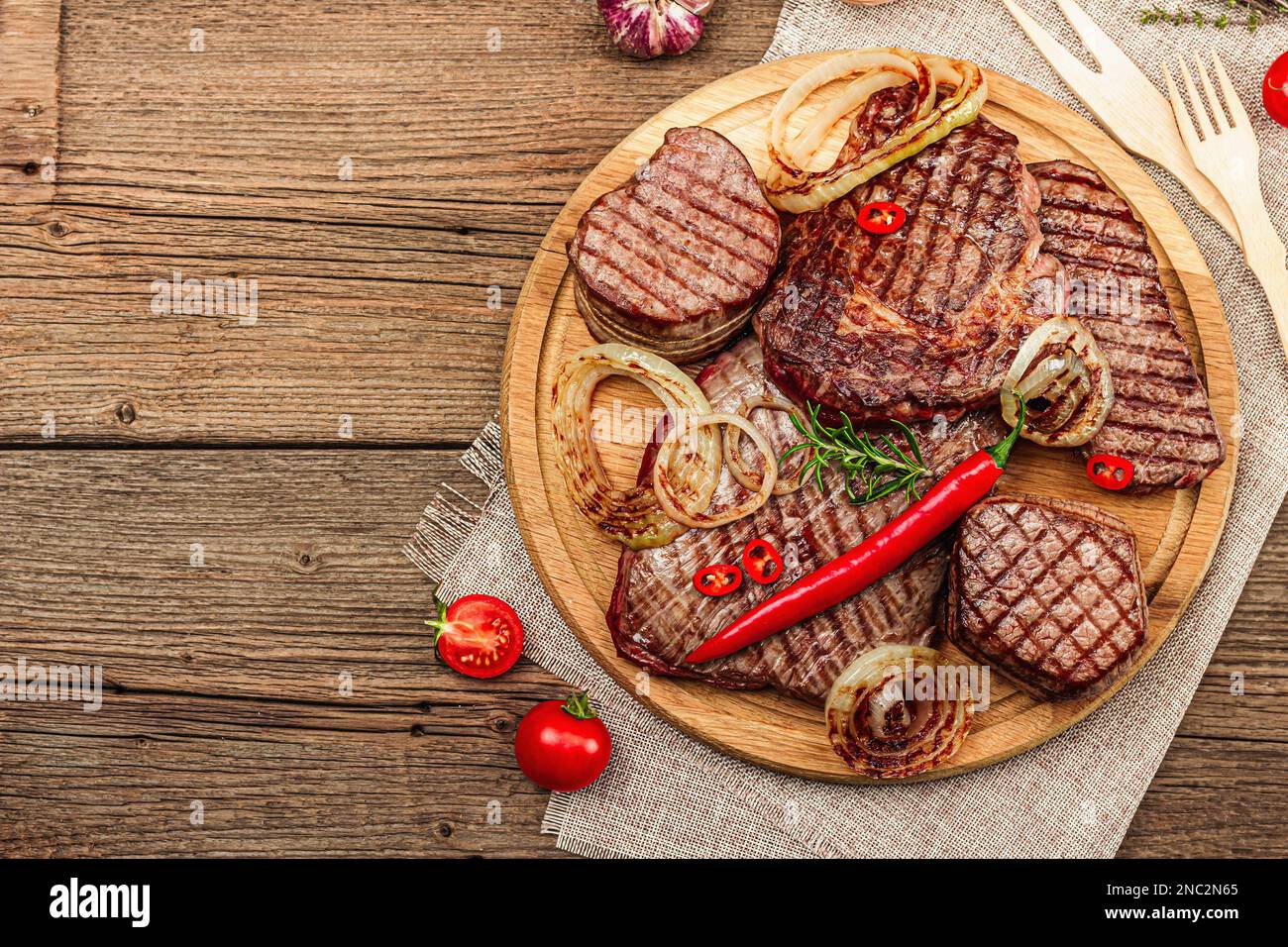 Grilled set of various steaks with vegetables, spices and herbs ...