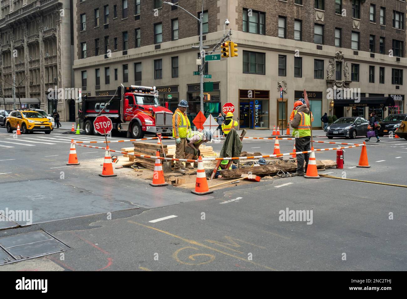 Workers dig a hole in the middle of the West 57th Street and Seventh ...