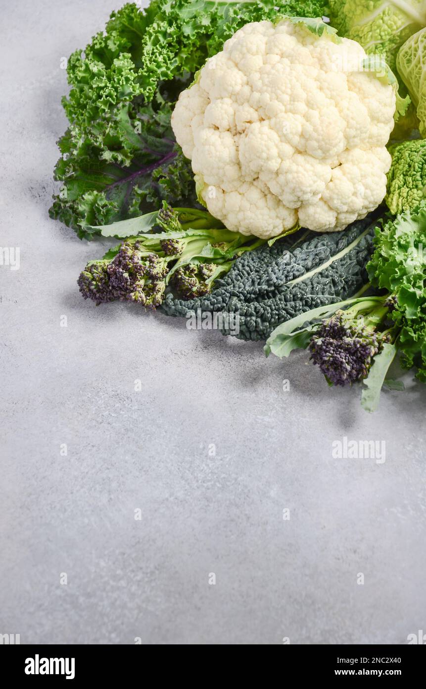 Different kinds of fresh organic cabbage on a gray concrete background ...
