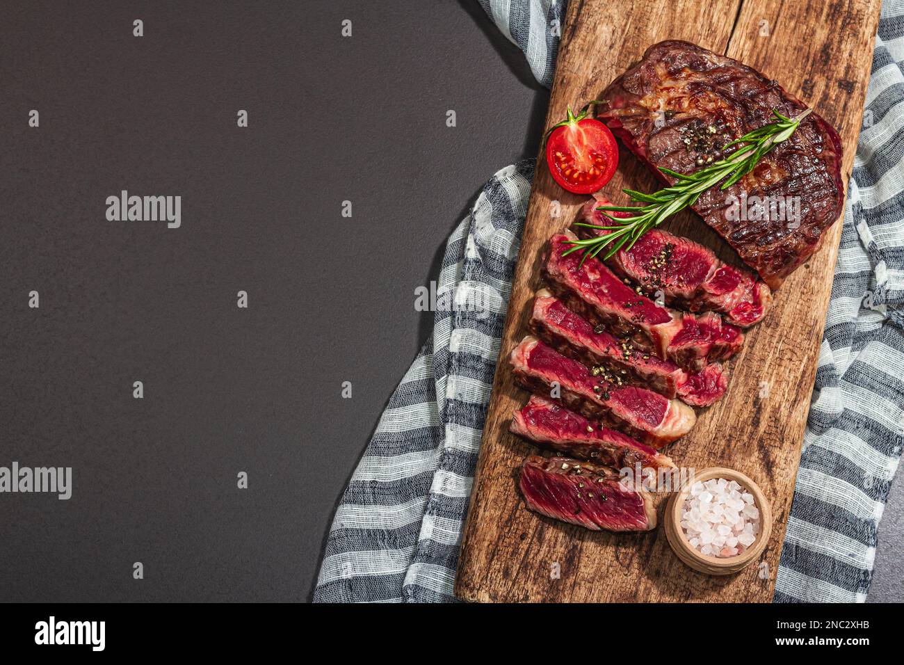 Rare cooking level Ribeye steak with spices and herbs. Classic grilled ...