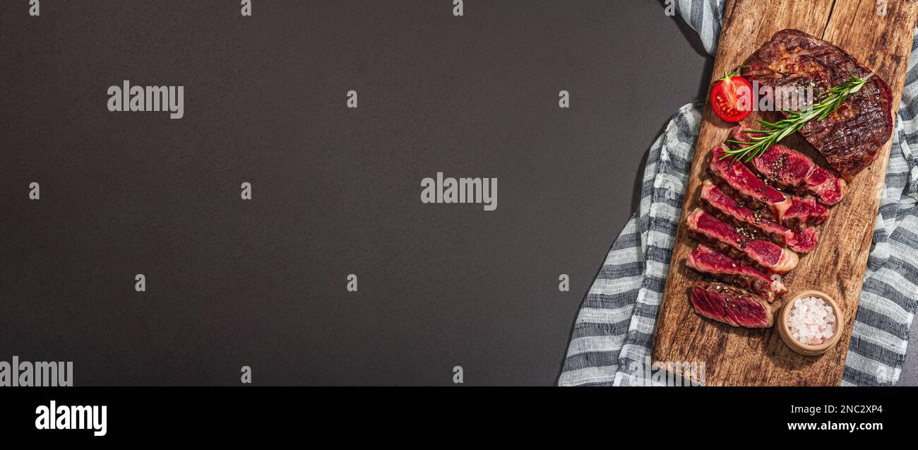 Rare cooking level Ribeye steak with spices and herbs. Classic grilled ...