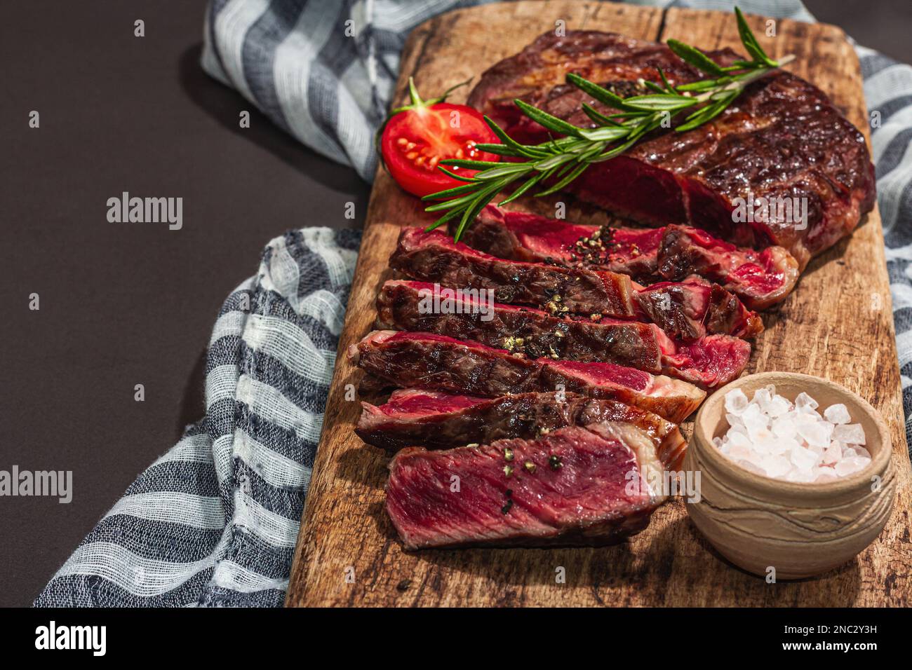 Rare cooking level Ribeye steak with spices and herbs. Classic grilled ...