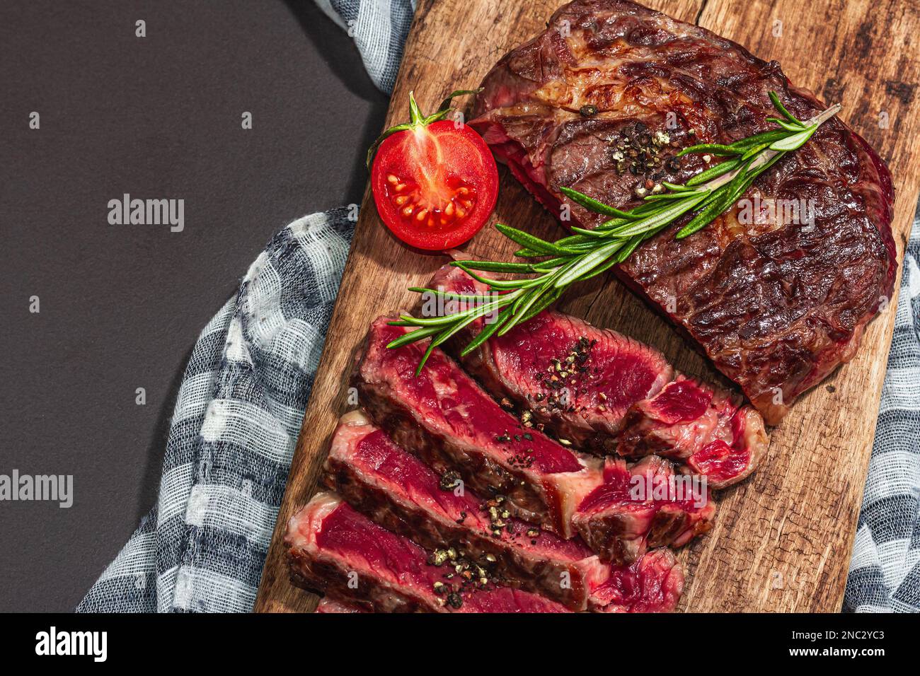 Rare cooking level Ribeye steak with spices and herbs. Classic grilled ...