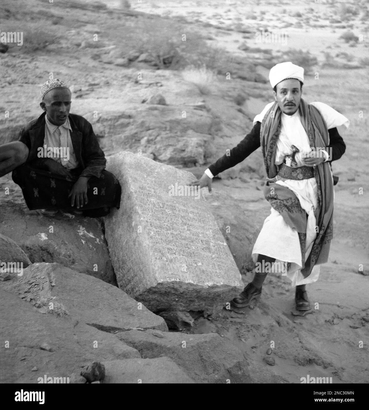 Two Yemenites standing beside stone containing himyaritic inscriptions ...