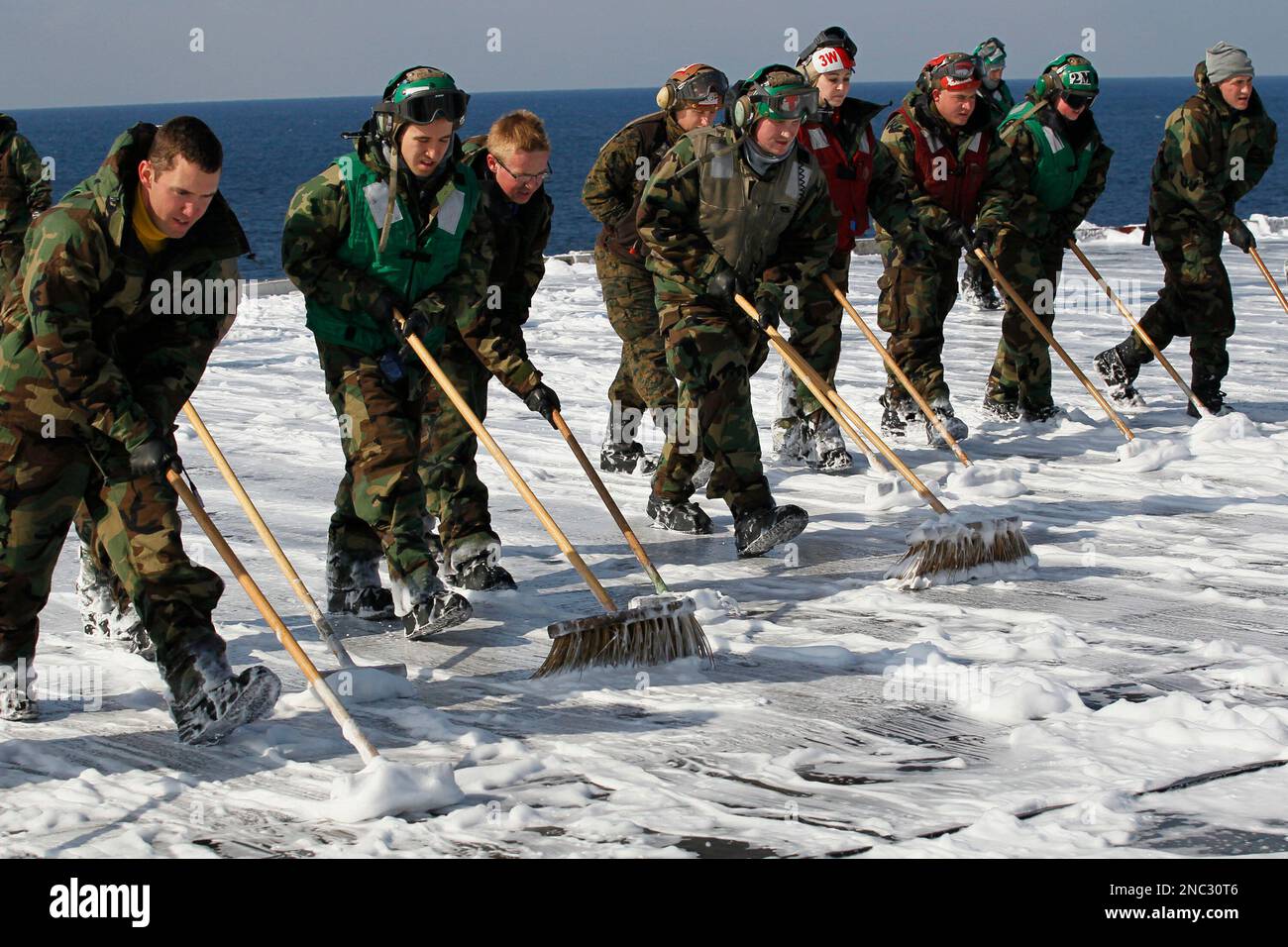 In this March 23, 2011 photo, U.S. Navy crew members mop up the flight ...