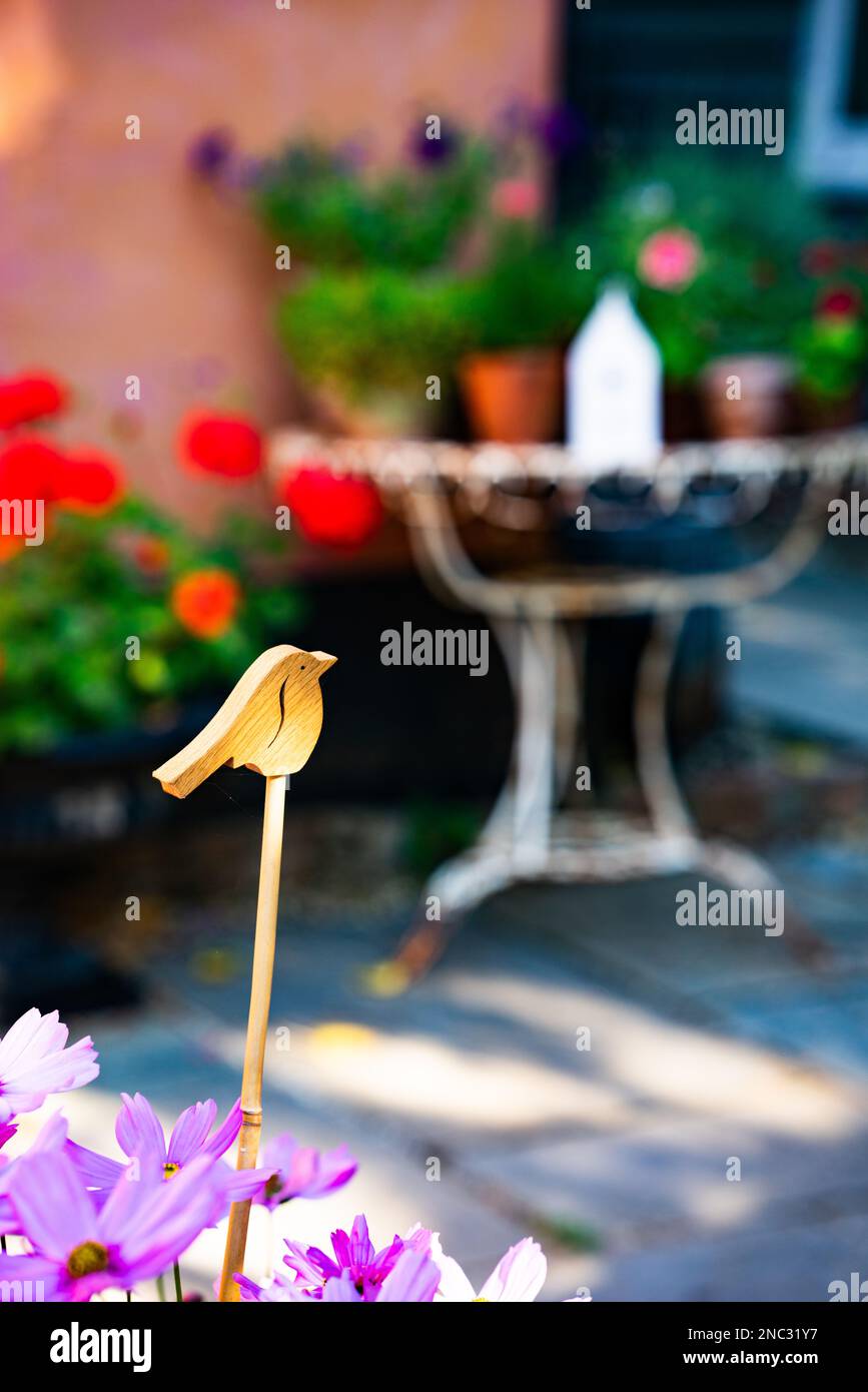 Cottage Garden with robin sculpture Stock Photo - Alamy