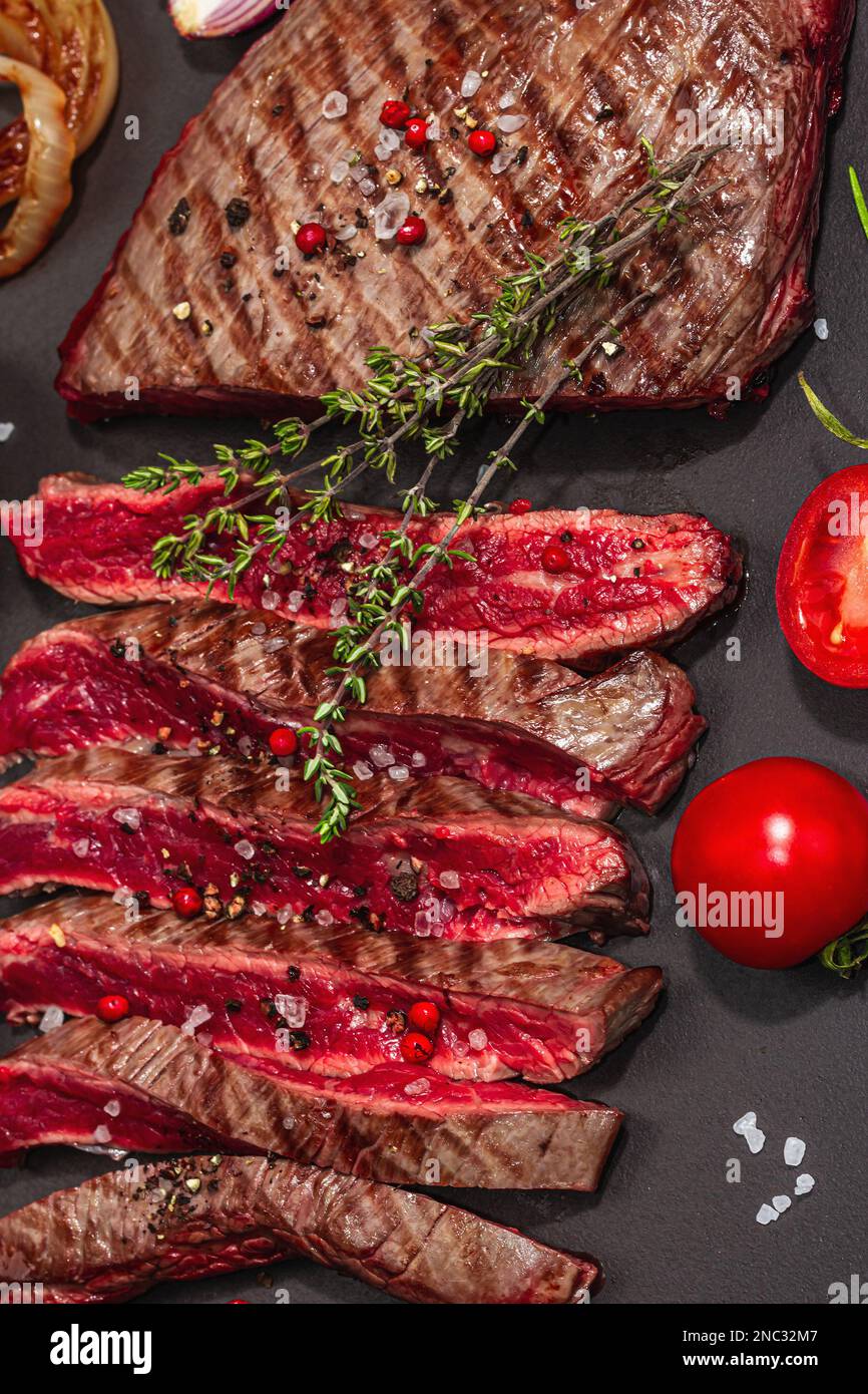 Grilled set of various steaks with vegetables, spices and herbs ...