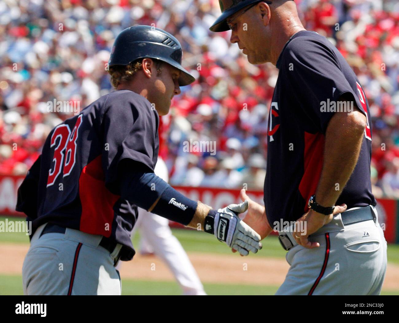 Minnesota Twins' Luke Hughes, left, rounds third to greetings from ...