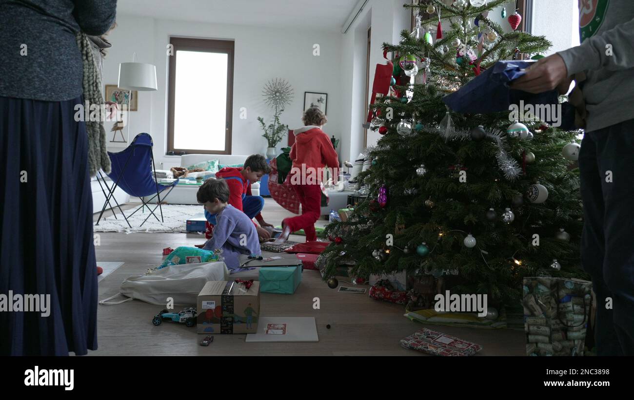 Family celebrating Christmas with present underneath table in the ...