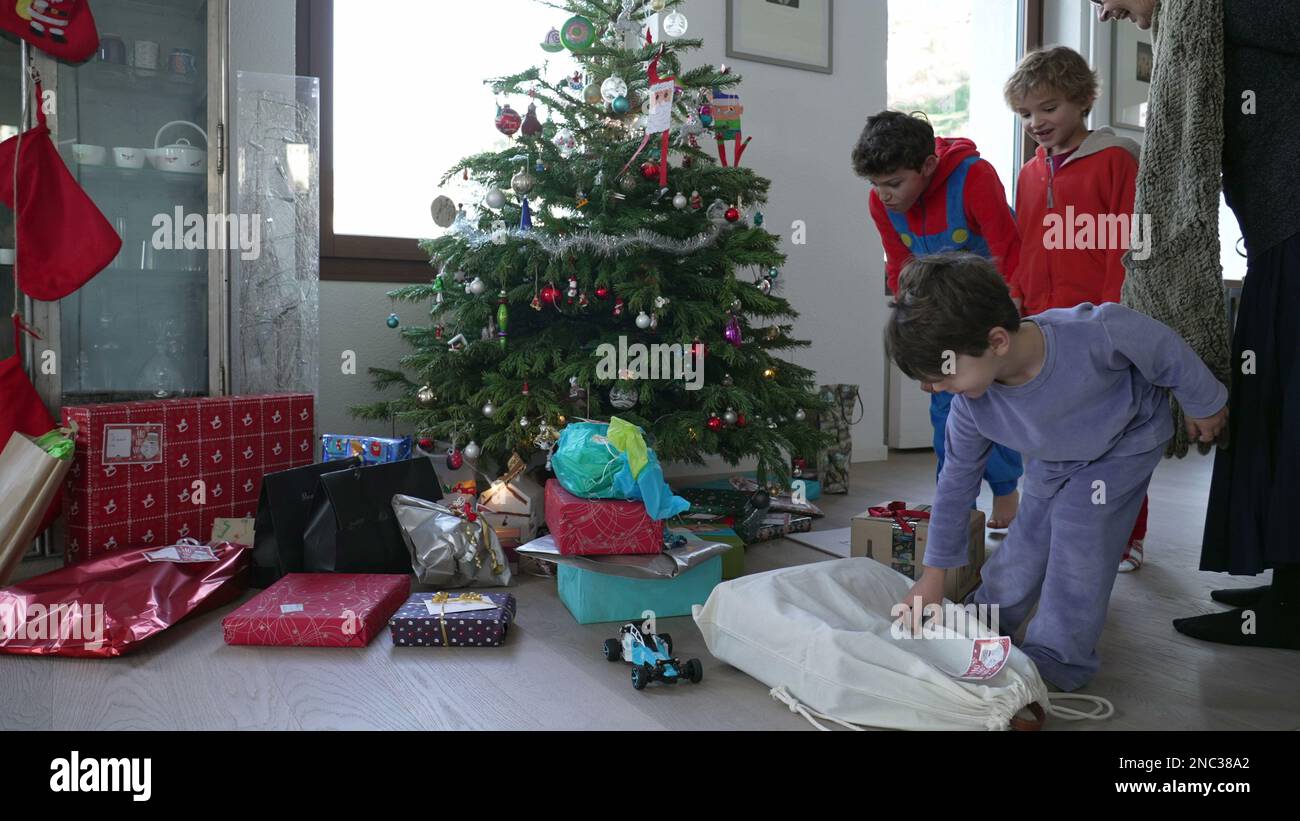 Family celebrating Christmas with present underneath table in the ...