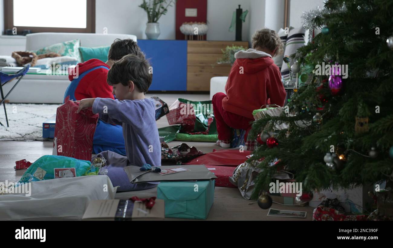 Children in Christmas morning with present underneath tree. Happy ...