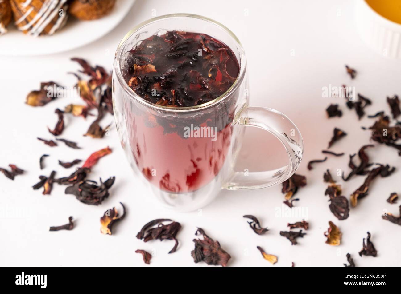 Red hibiscus tea from the petals of the Sudanese rose in a glass cup ...