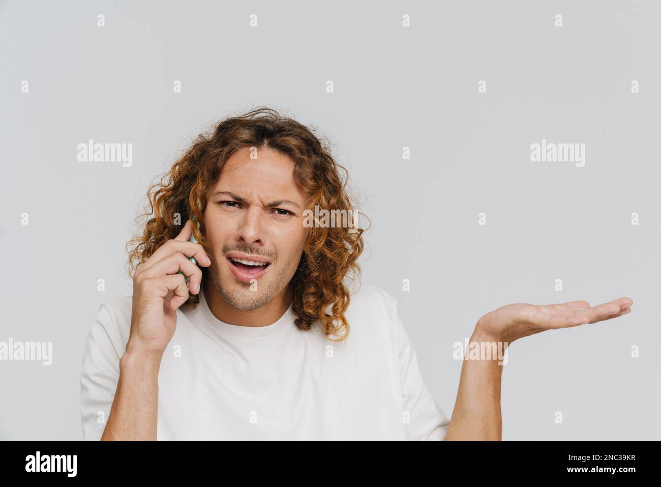 Ginger european man expressing outrage while talking on cellphone ...