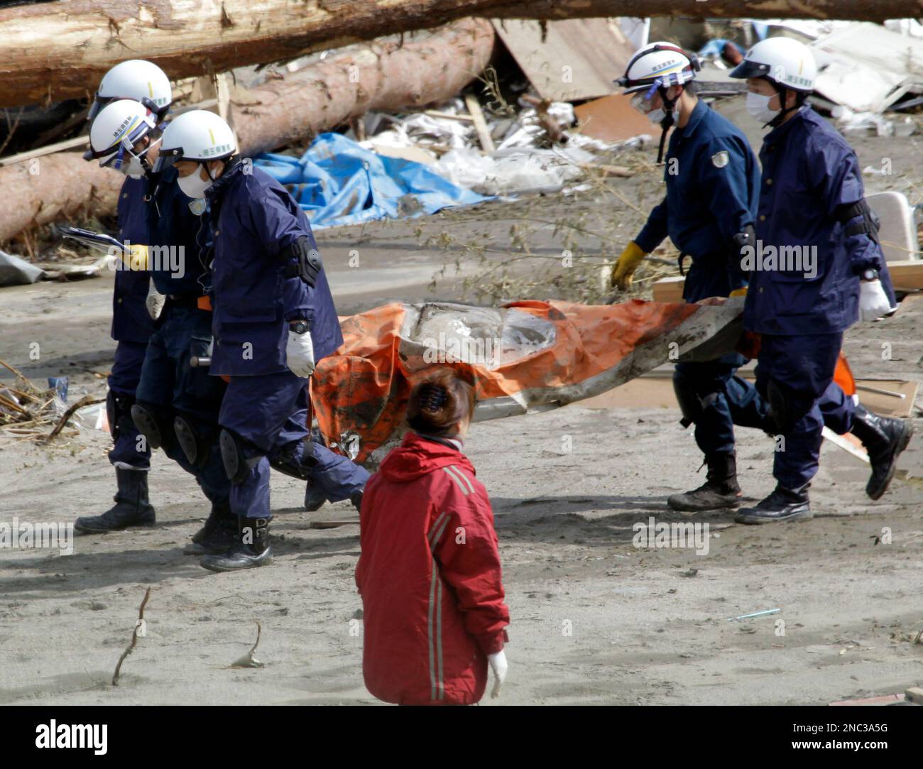 Police officers carry a body during a search and rescue operation in ...