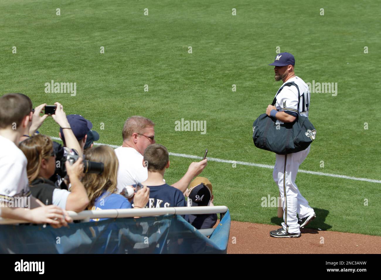 Milwaukee Brewers' Casey McGehee, right, looks to fans as he walks to ...