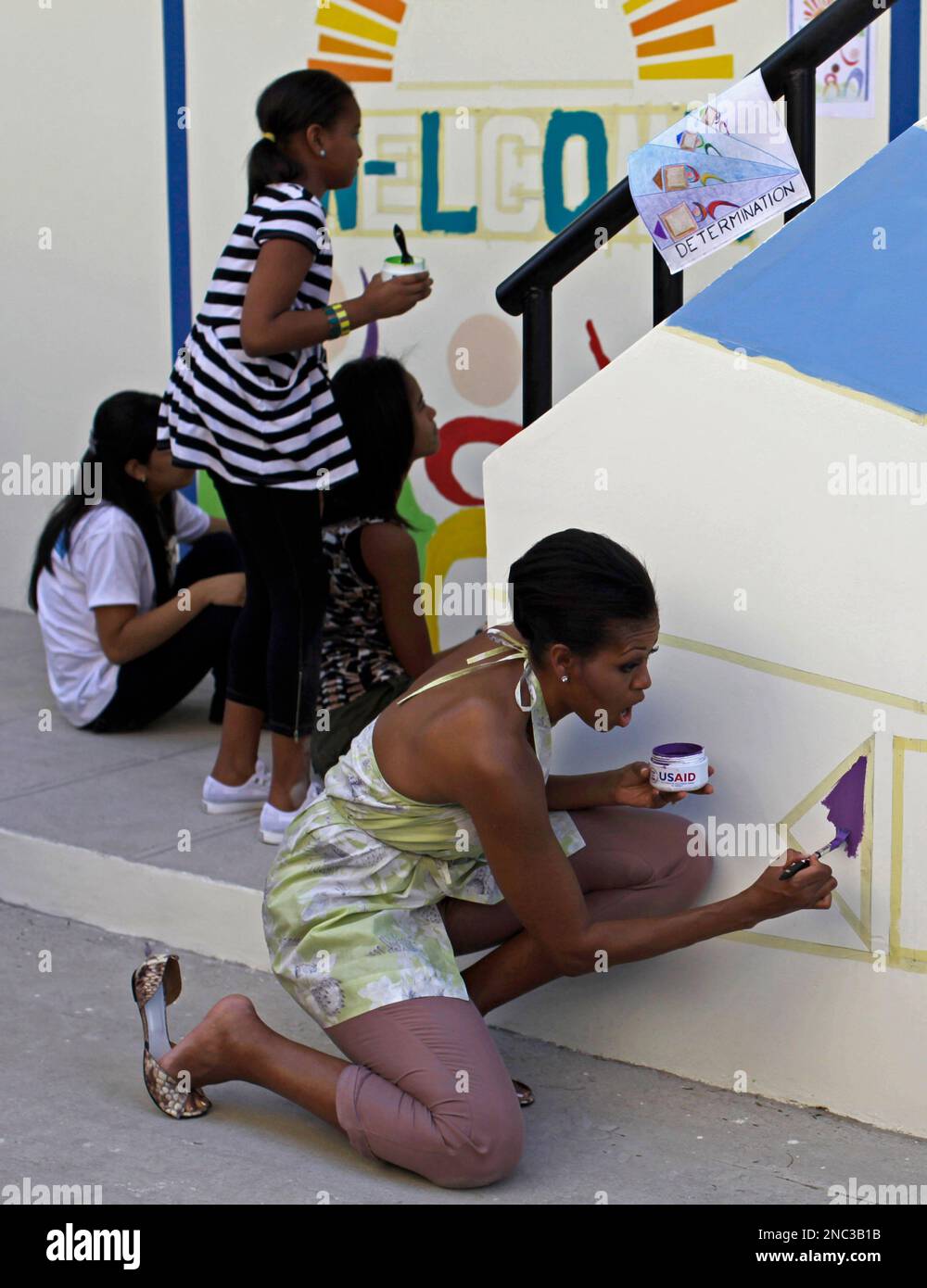 First lady Michelle Obama, center, helps paint a mural with students at ...