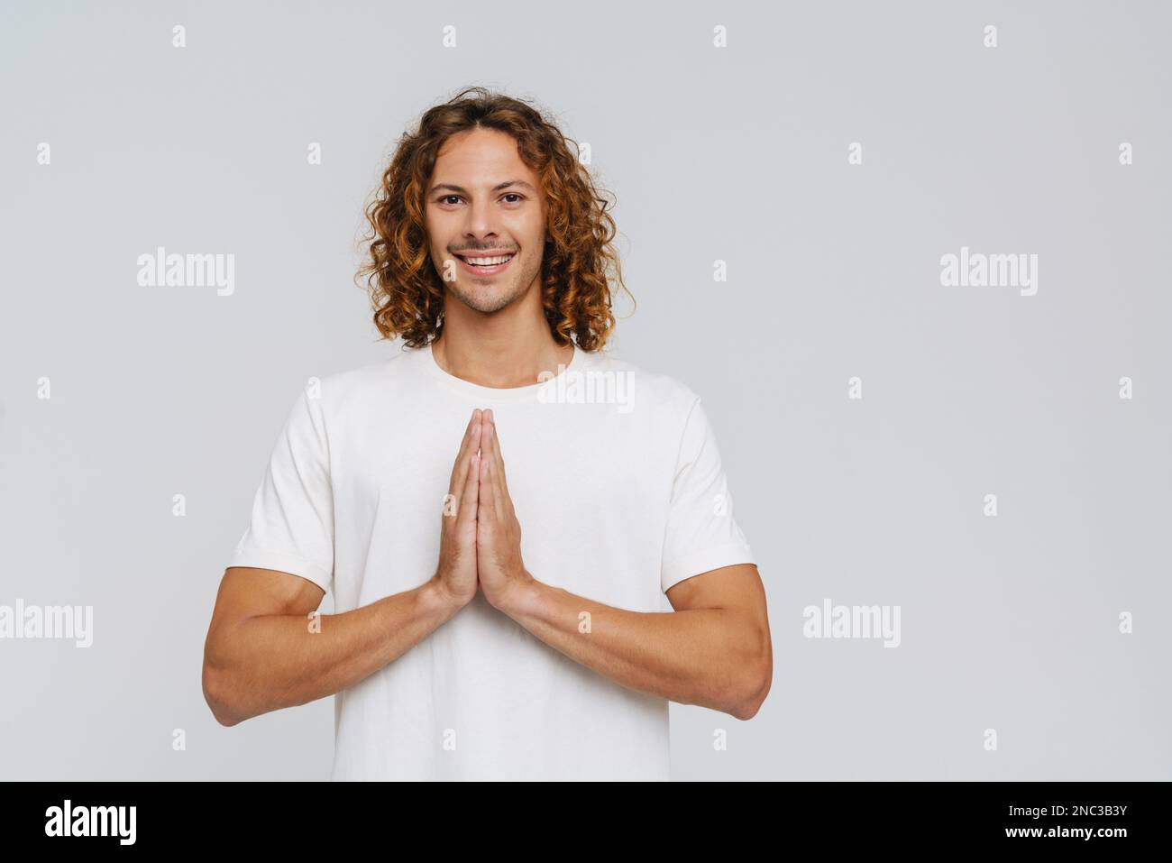 Ginger european man smiling while making pray gesture isolated over ...