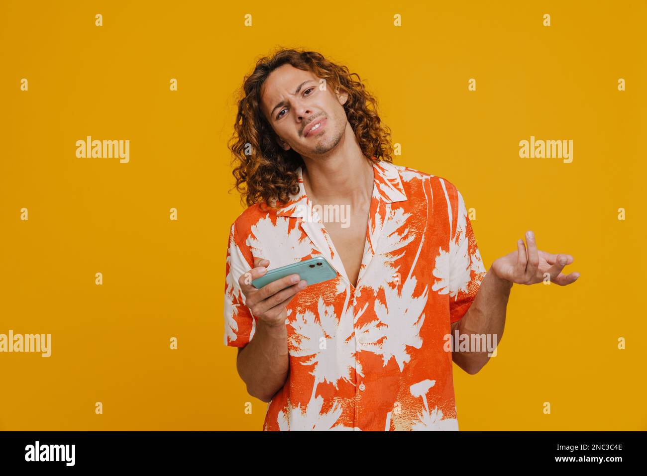 Ginger european man frowning and gesturing while using cellphone ...