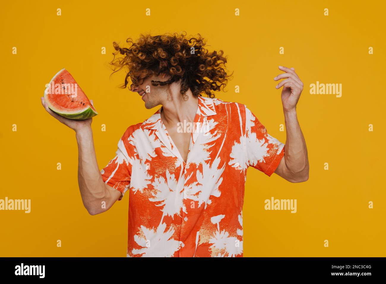 Ginger man in sunglasses laughing while dancing with watermelon ...