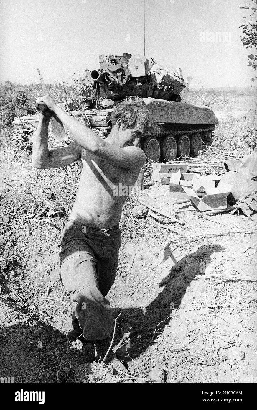 An American soldier swings a pick as he digs his foxhole near Khe Sanh ...